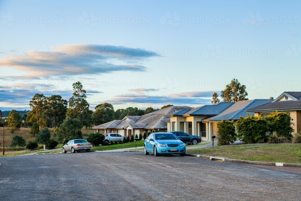 Image of Car Parked outside of houses at dusk on the outskirts of town ...