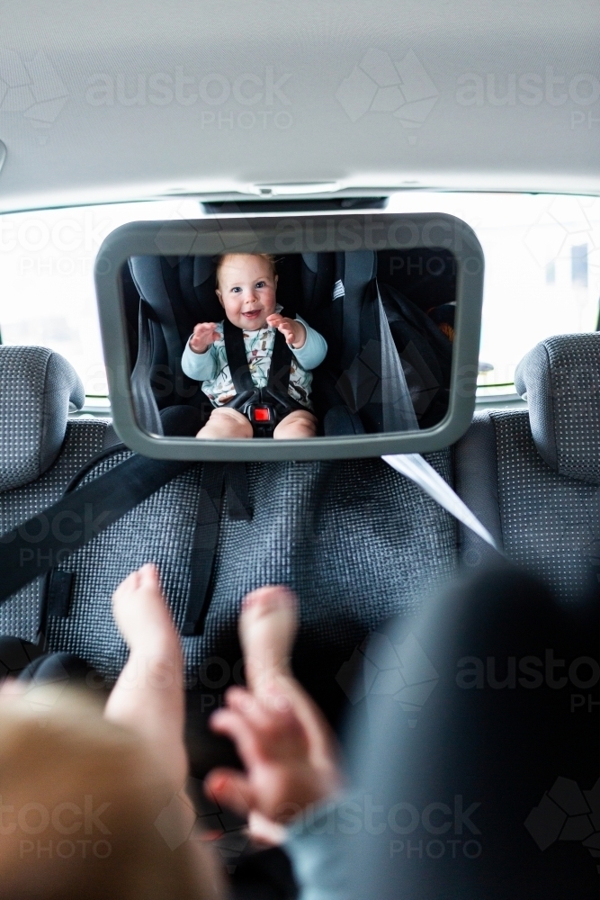 Image of Car seat mirror with happy baby face reflected in rear facing ...