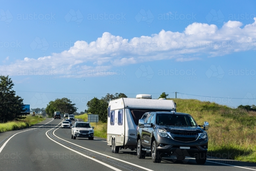 Image of Car towing caravan on road trip through countryside on sunny ...