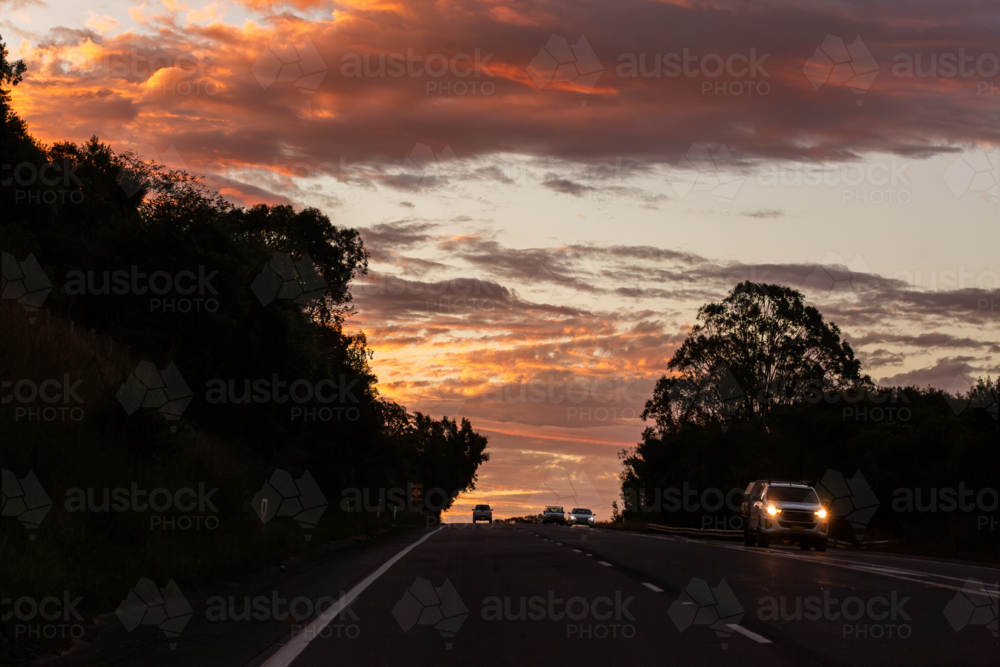 Image of car traveling on road towards crest at the end of the day with ...