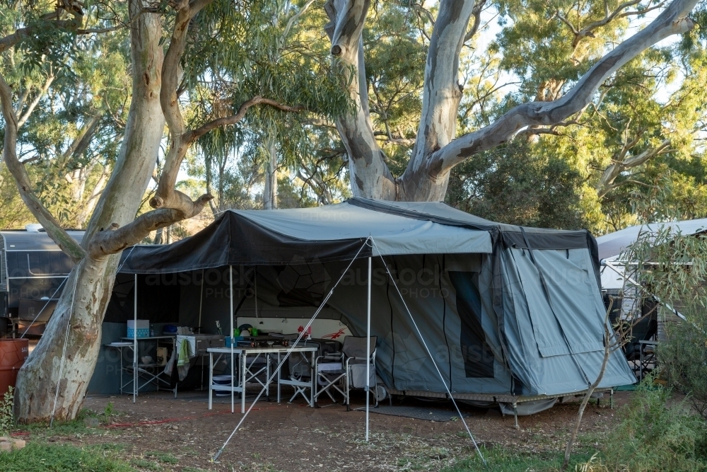 Image of Caravan with awning surrounded by gum trees. - Austockphoto