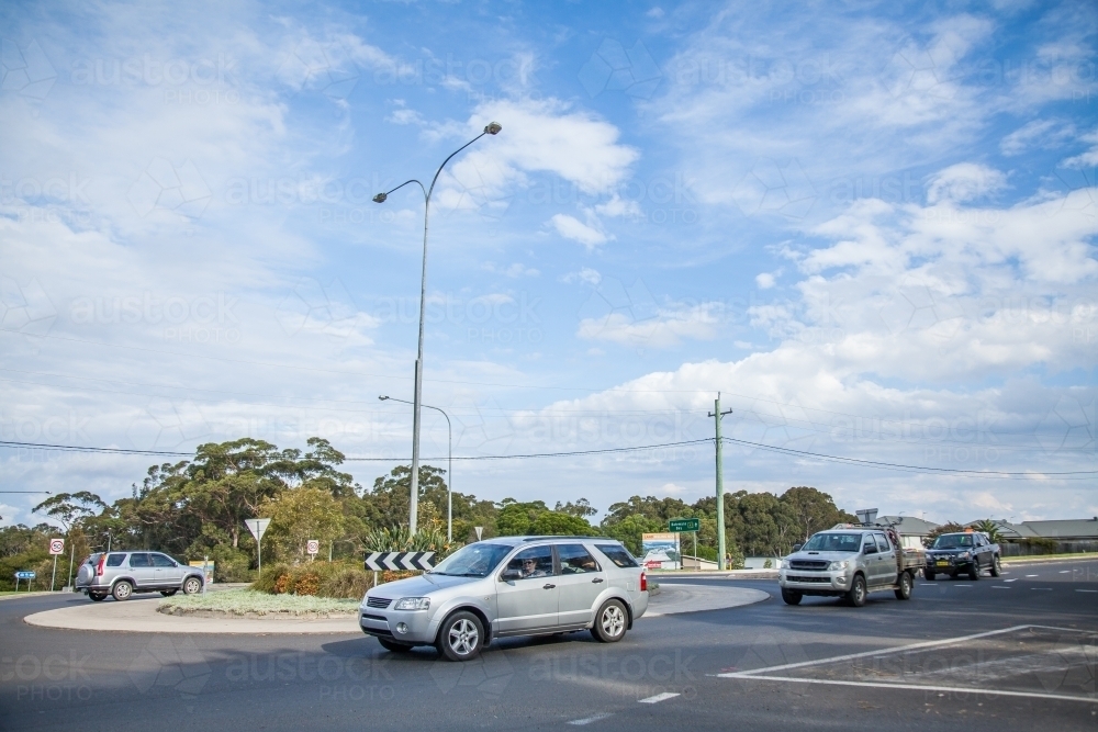 Image of Cars driving around a roundabout - Austockphoto