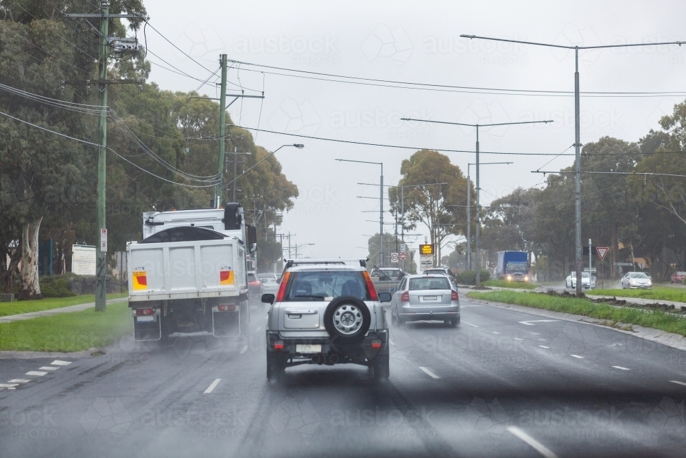 Image of Cars driving on road in city in wet rainy hazardous weather ...