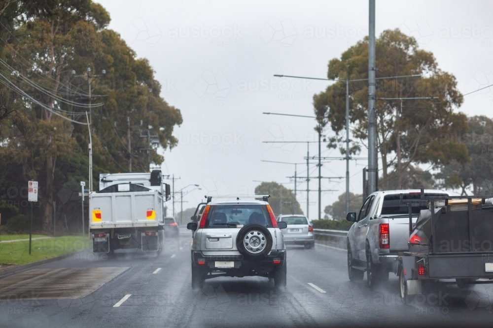Image of Cars driving on road in city in wet rainy hazardous weather ...