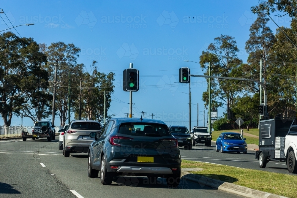 Image of Cars going through green traffic lights at intersection ...