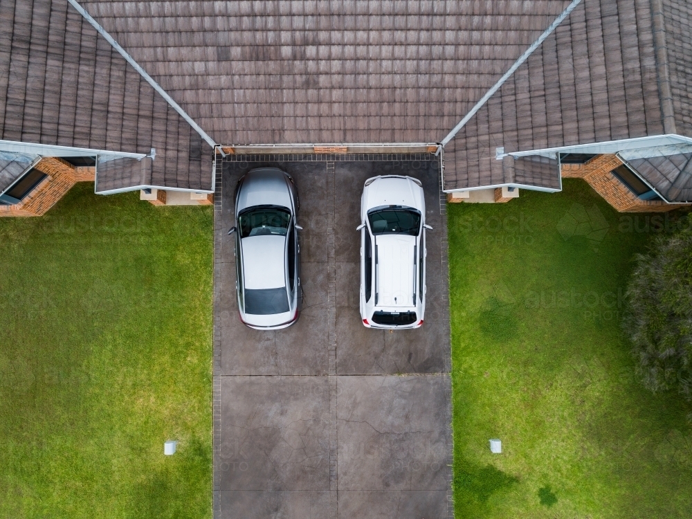 Image of Cars parked in driveway of unit house - Austockphoto