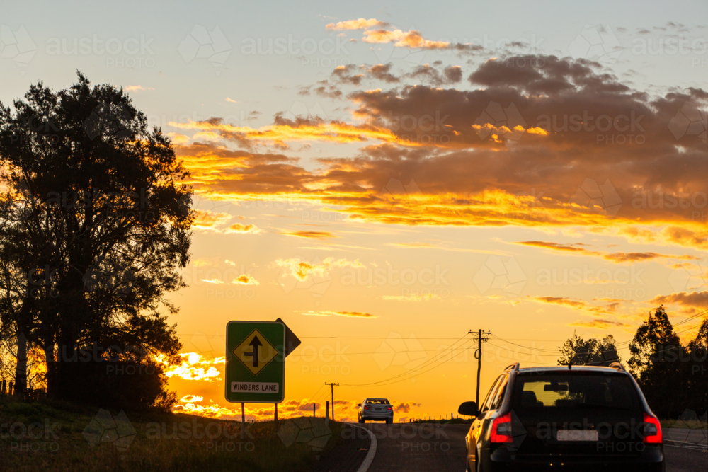 Image of cars traveling on road towards crest at the end of the day ...