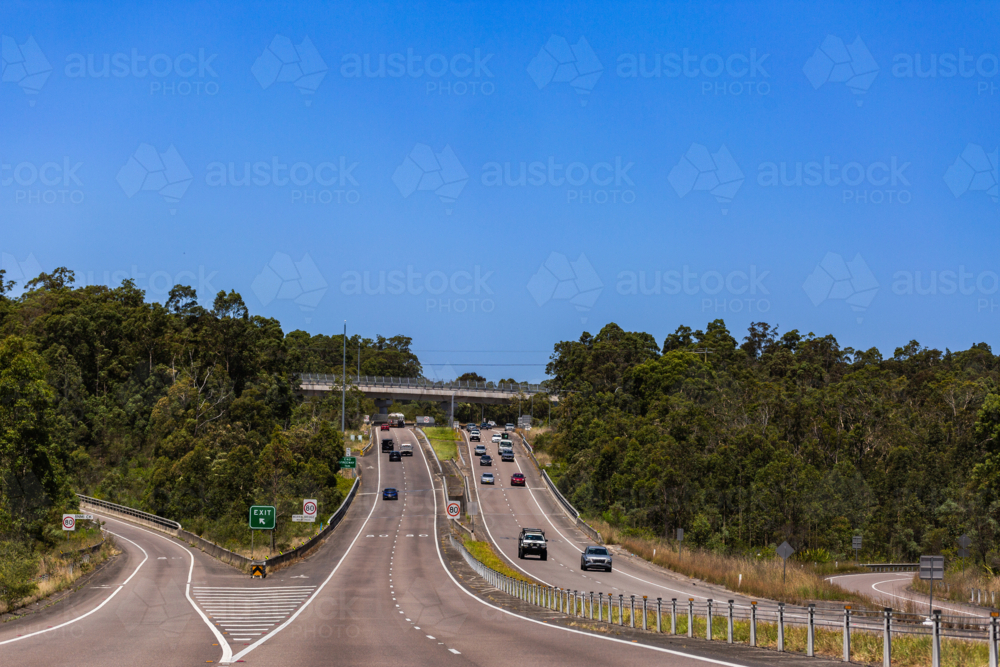 Image of cars travelling on highway with exit sign with speed change to ...