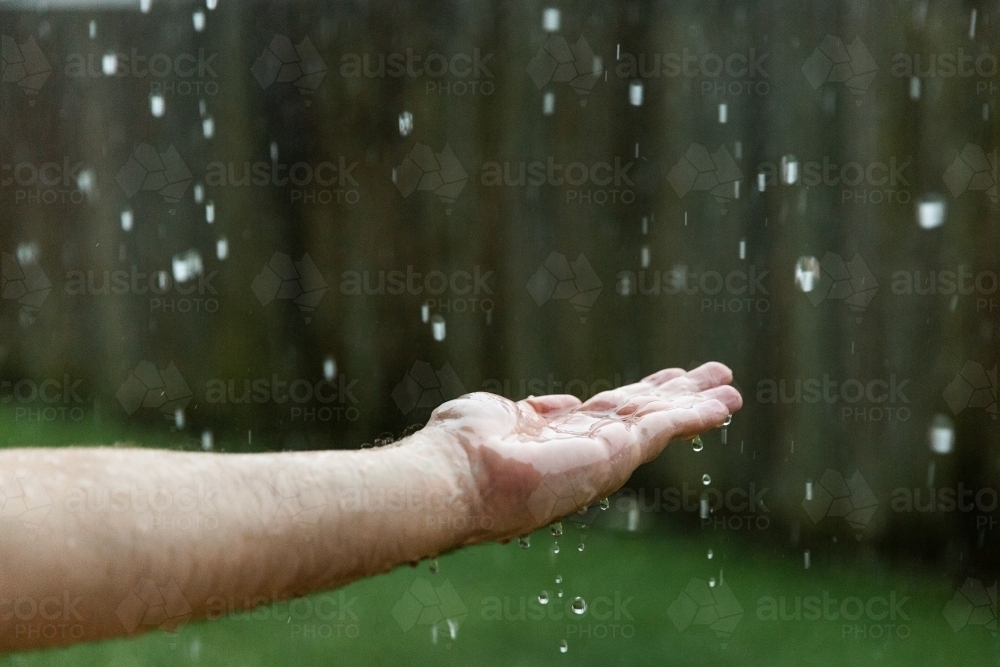 Image of catching rain in a hand - Austockphoto