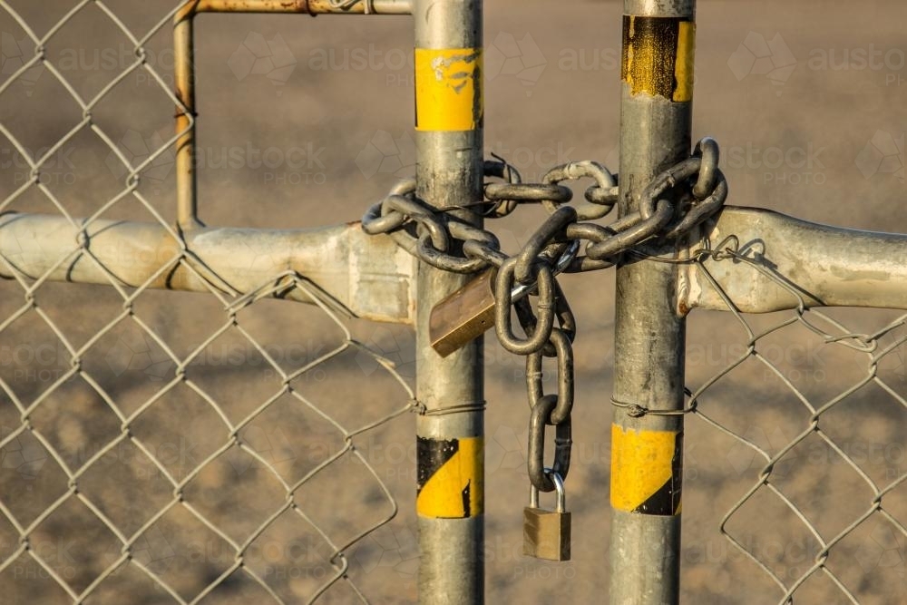 Image of Chain and padlocks holding a gate in an industrial state ...