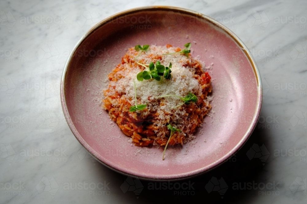 Image of Cherry tomato sugo risoni in a pink bowl - Austockphoto