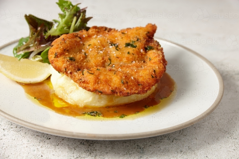 Image of Chicken schnitzel on mash with gravy and lemon - Austockphoto
