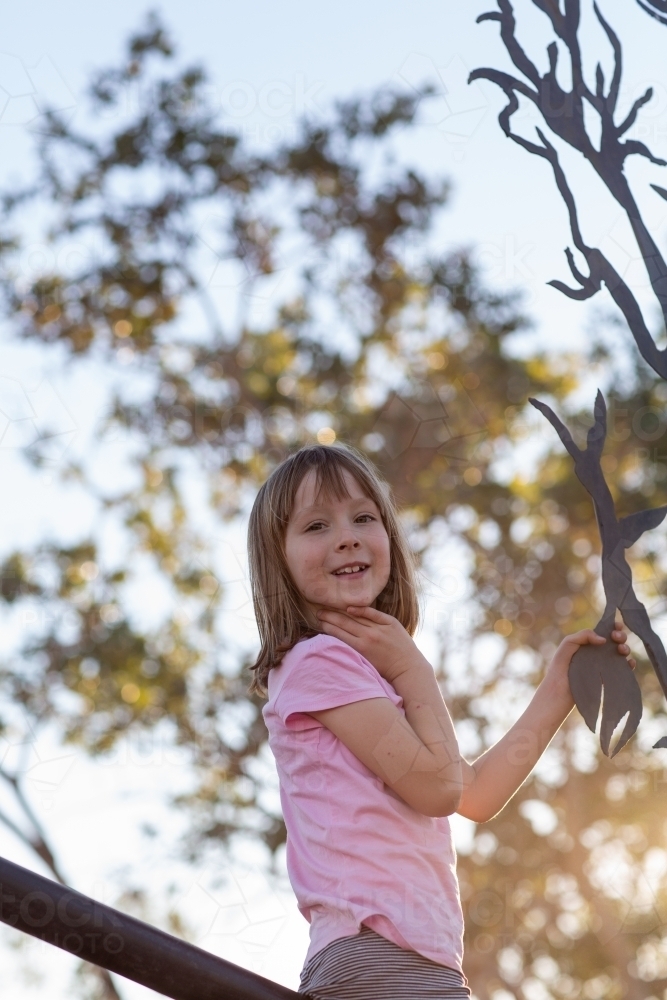 Image of Child climbing on a fence in the outback - Austockphoto
