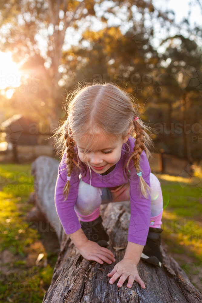 Image of Child crawling on log outdoors playing game in nature ...