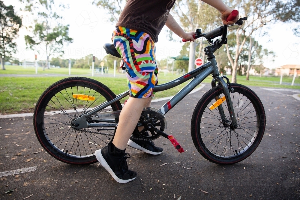 Image of child getting ready to ride a bike - Austockphoto