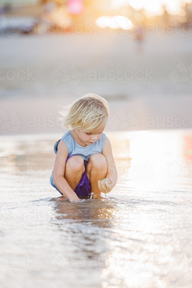 Image of Child playing in shallow water on Gold Coast beach in golden ...