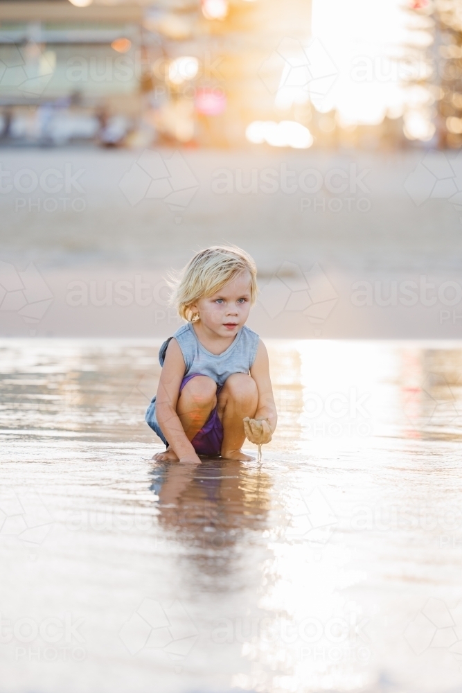 Image of Child playing in shallow water on Gold Coast beach in golden ...