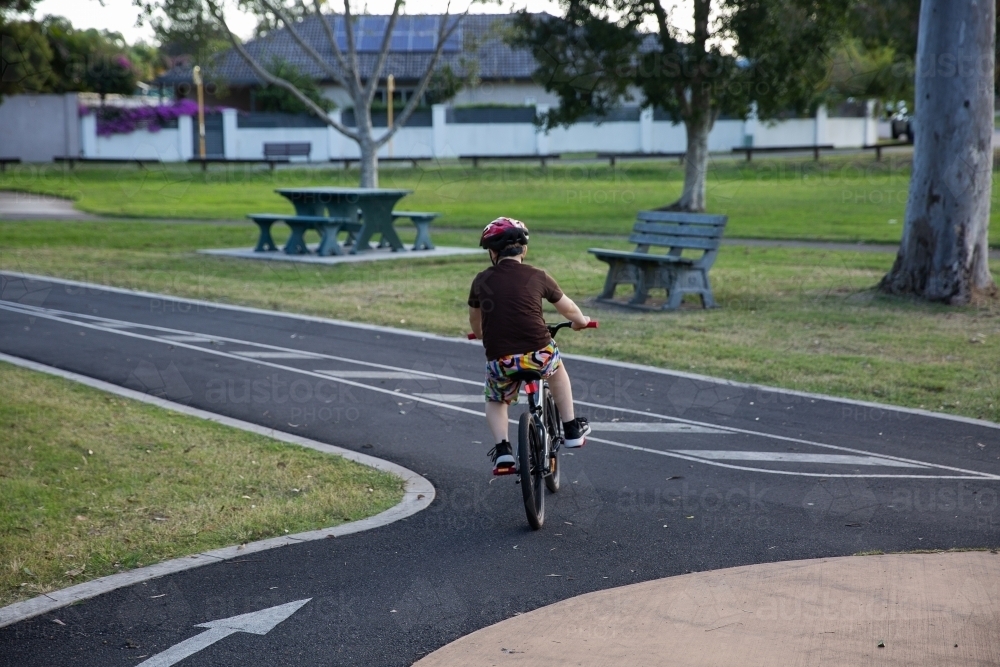 Image of child riding a bike around a local bike path with road ...