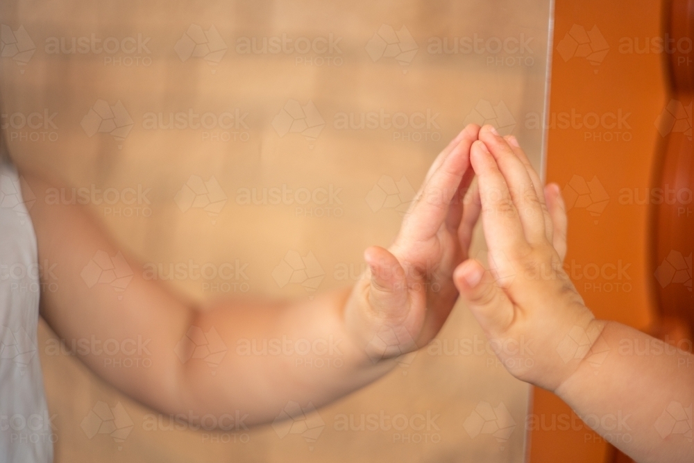 Image of Child's hand reflection in the mirror - Austockphoto