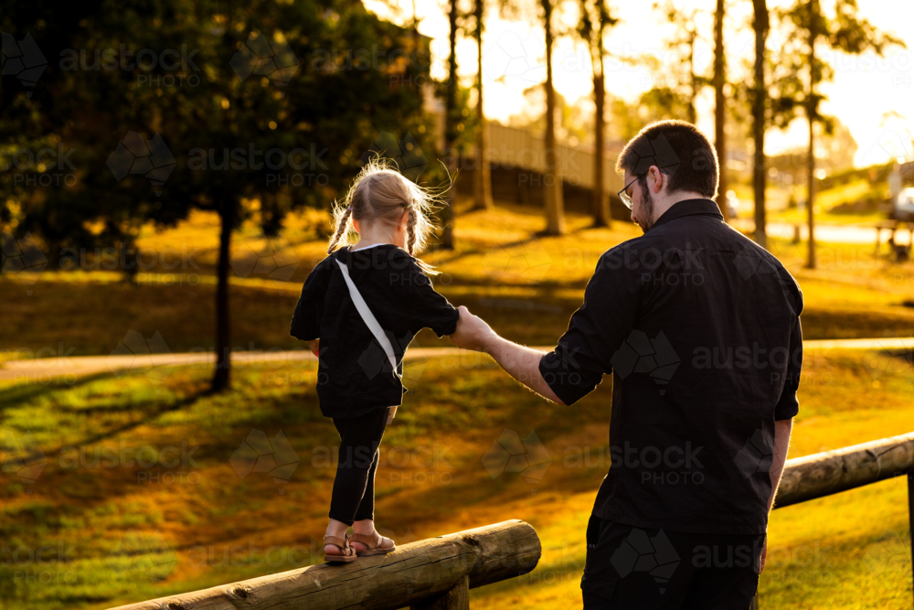 Image of Child showing trust walking along post holding to fathers hand ...