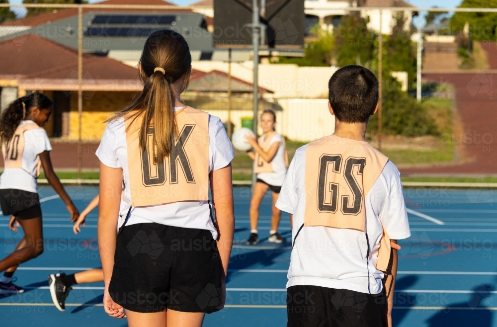 Image of children at netball training on blue playing surface and ...