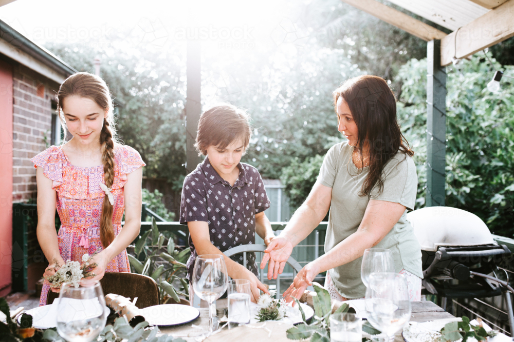 Image of Children helping mum set up the table. - Austockphoto