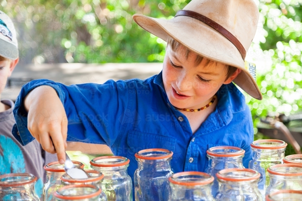 Image of Children helping with preserving fresh fruit in canning jars ...
