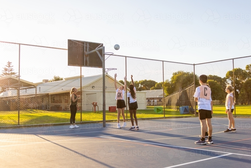 Image of children training for netball on outdoor court - Austockphoto