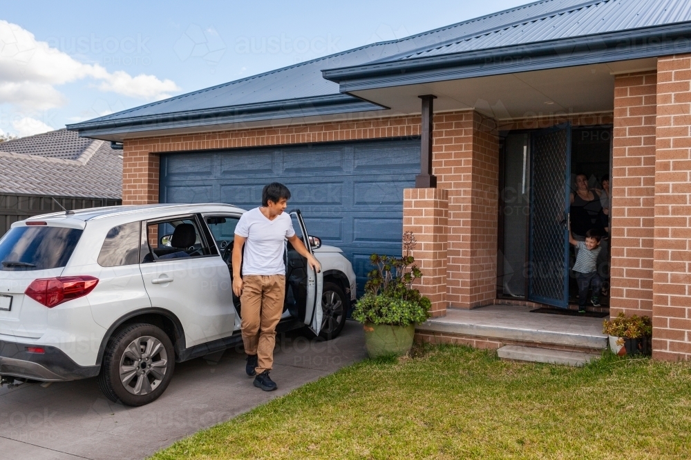 Image of Chinese Australian dad arriving home from work greeting family ...