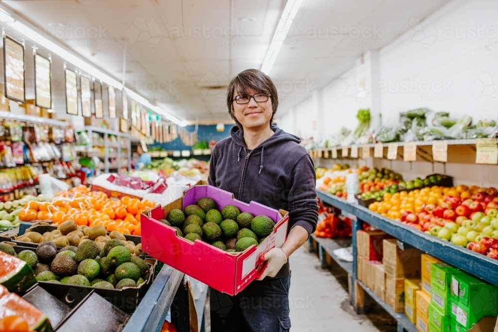 Image of Chinese man working in fruit supermarket - Austockphoto