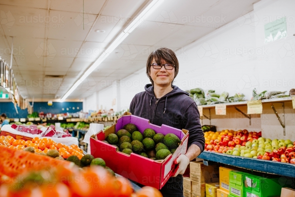 Image of Chinese man working in fruit supermarket - Austockphoto