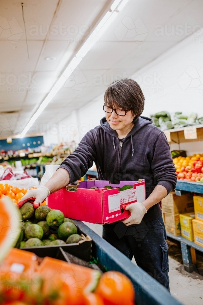 Image of Chinese man working in fruit supermarket - Austockphoto