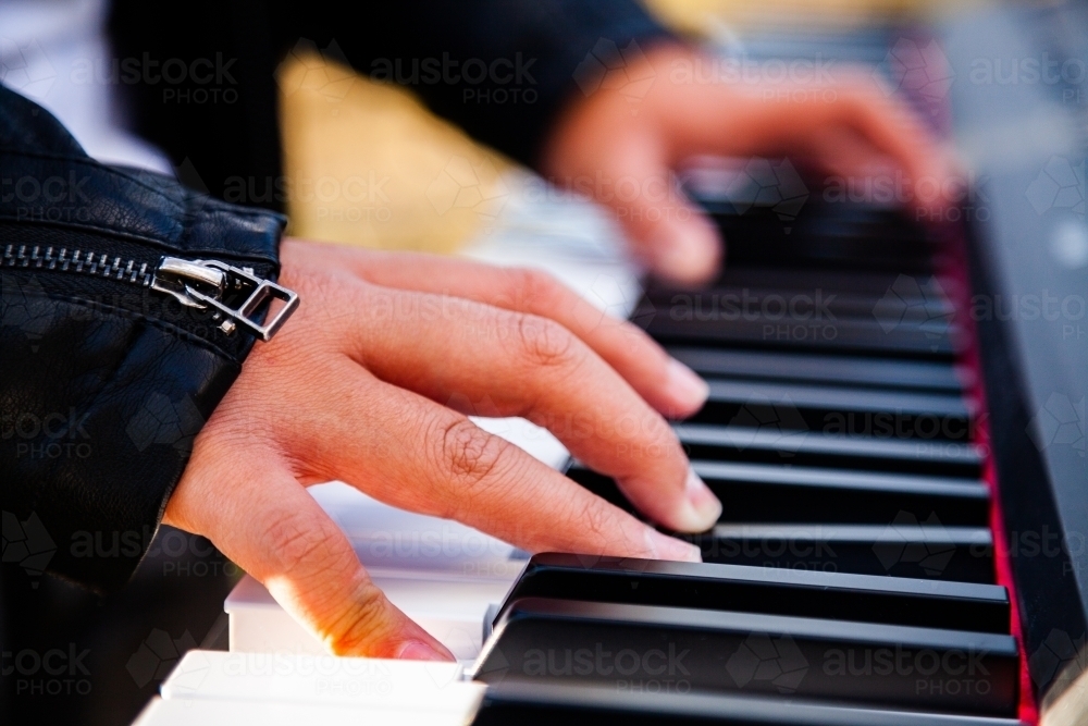 Image of Close up detail of boy playing keyboard keys - Austockphoto
