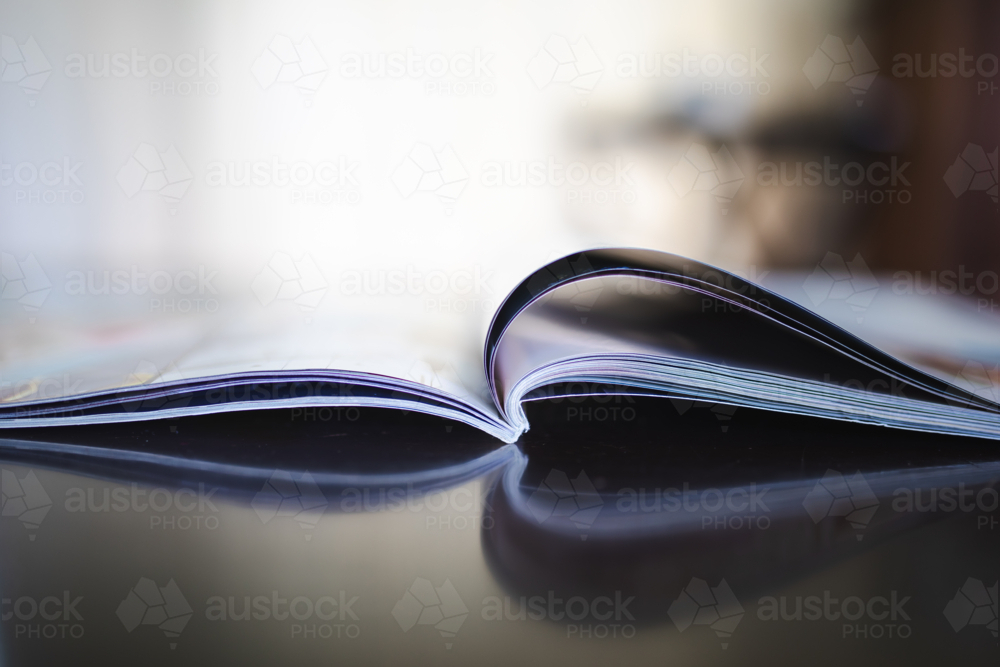 Image of Close up details of open magazine on coffee table with copy ...