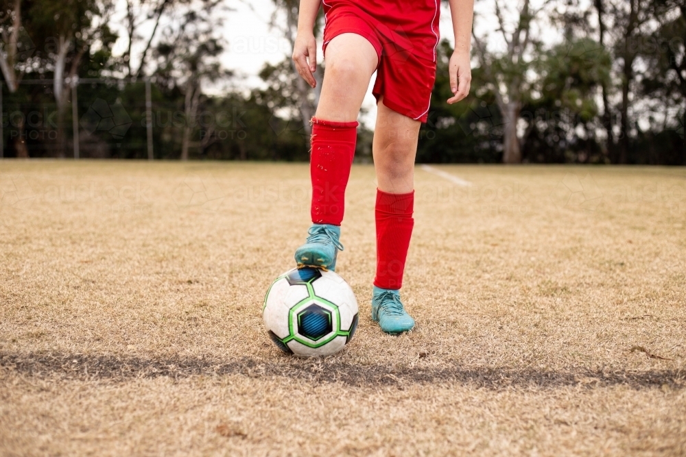 Image of Close-up of a girl's foot on a soccer ball at a sports oval ...