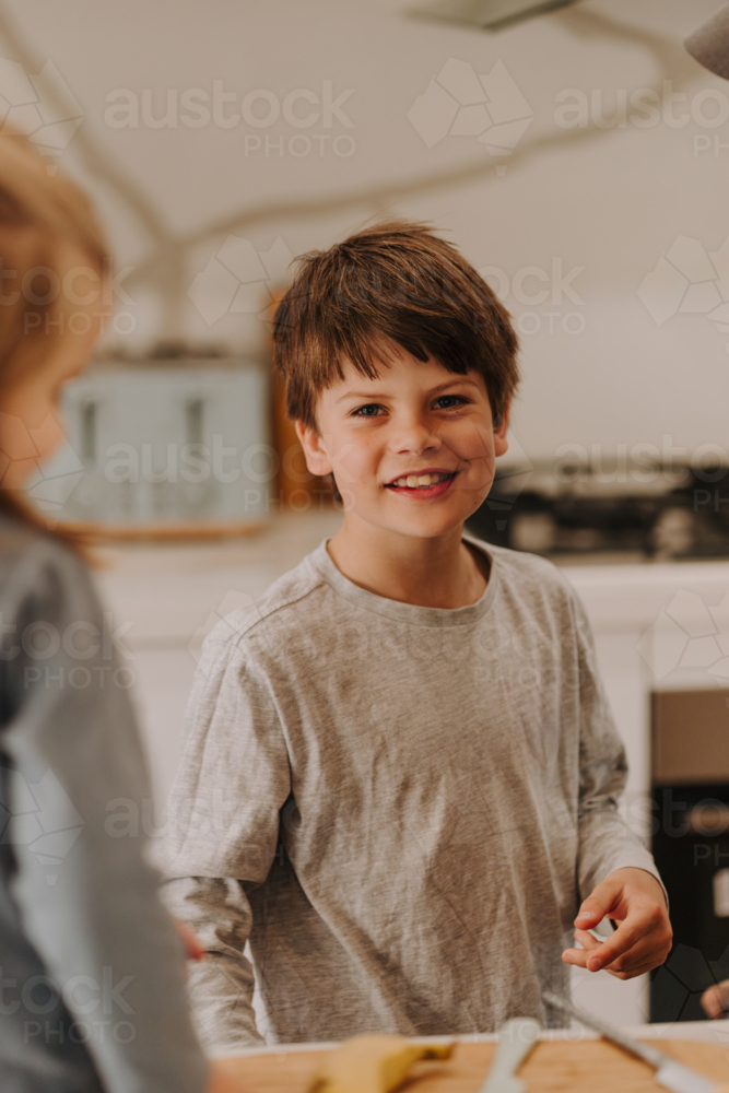 Image of Close-up of a happy young boy standing near the kitchen ...