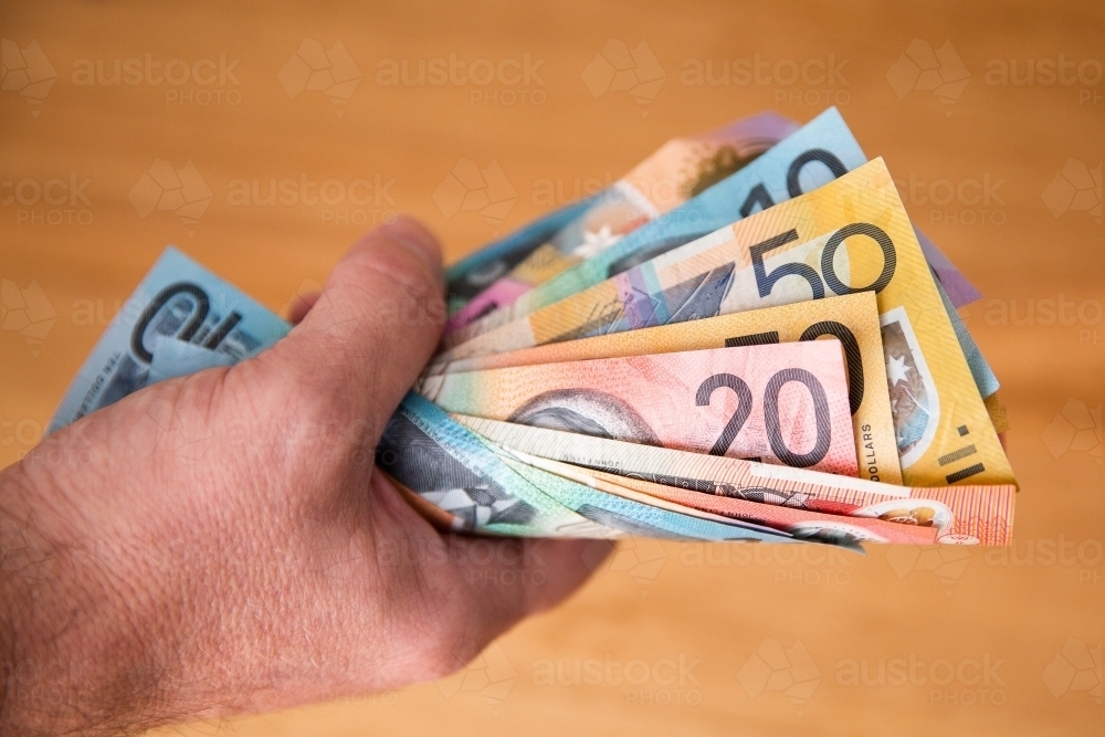 Image of close up of a man holding Australian money - Austockphoto