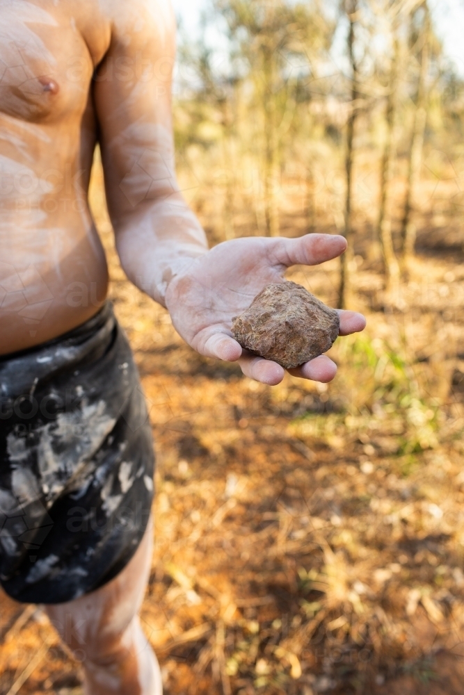 Image of Close up of Aboriginal artefact held in hand axe head or ...