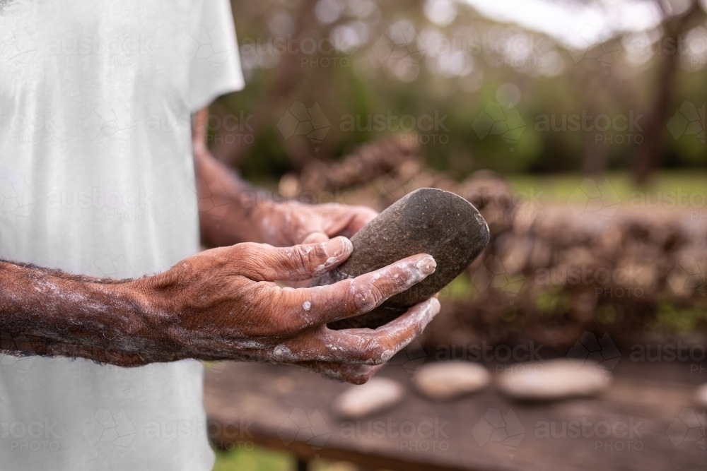 Image of close-up of aboriginal man's hands holding a sacred rock ...