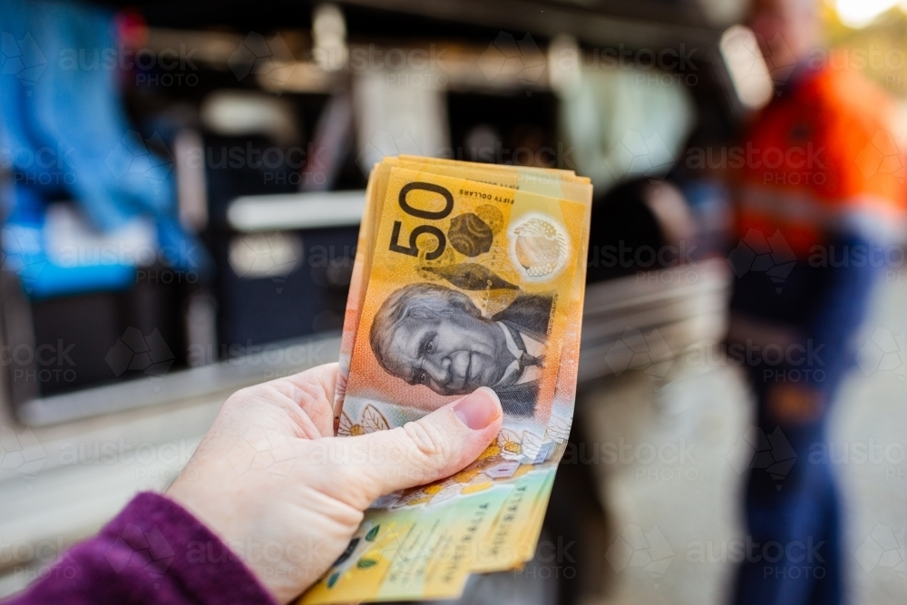 Image of Close up of cash payment in woman's hand to pay tradesman for ...