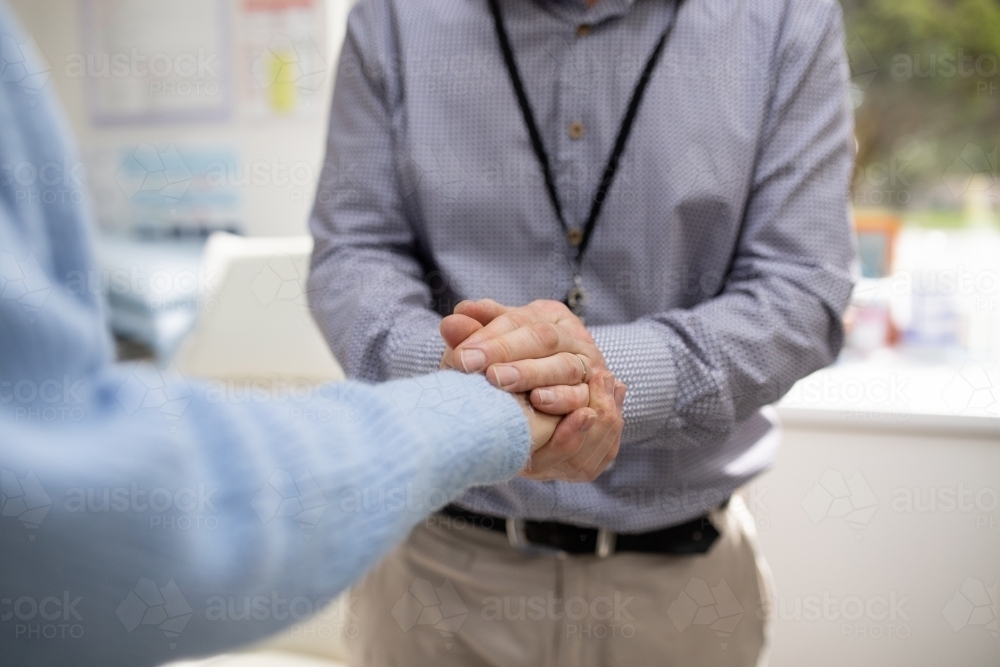 Image of Close up of doctor's hands reassuring his patient - Austockphoto