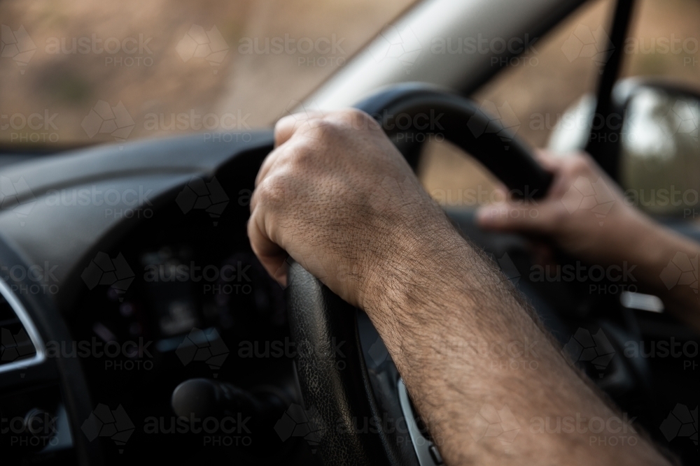 Image of close up of driver hands on a steering wheel - Austockphoto