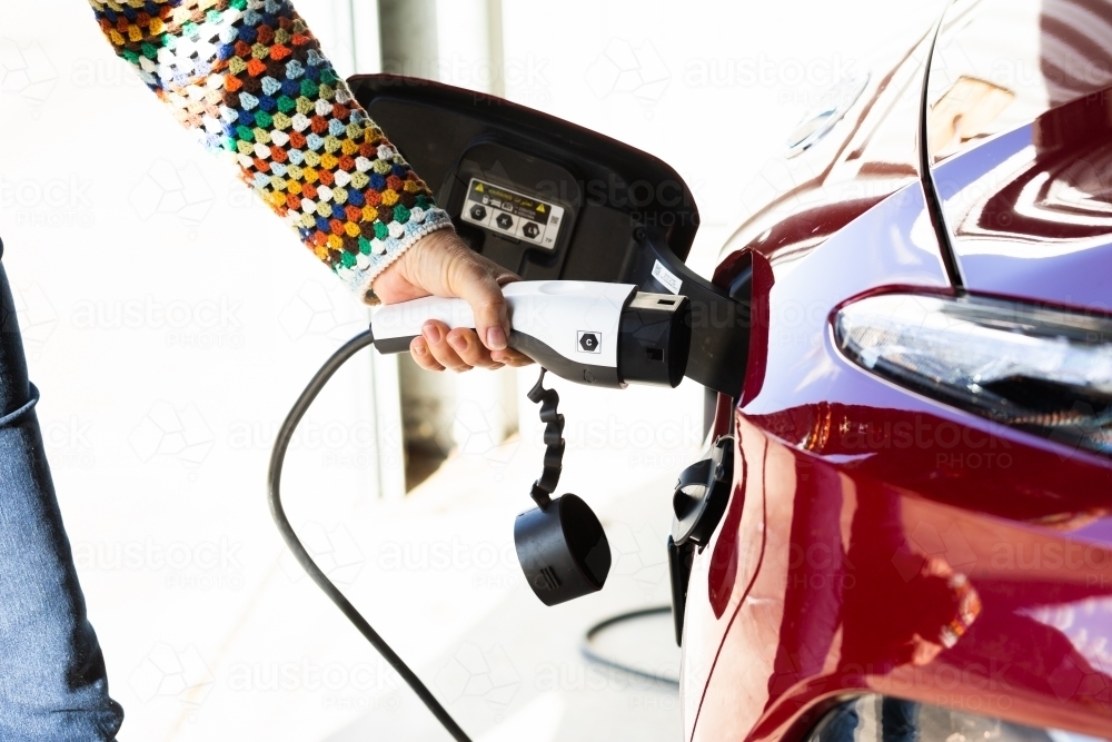 Image of Close up of electric vehicle charging plug being plugged into ...