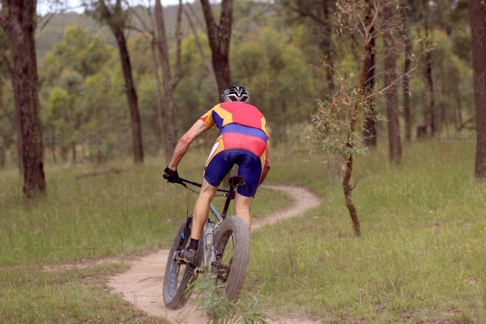 Image of Close up of male cyclist riding pushbike on trail through ...