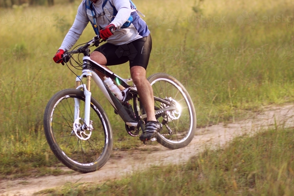 Image of Close up of male cyclist riding pushbike on trail through ...
