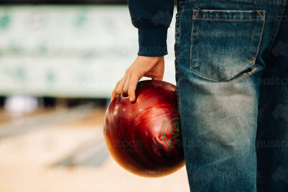 Image of Close up of teenage boy's hand holding red ball while ten pin ...