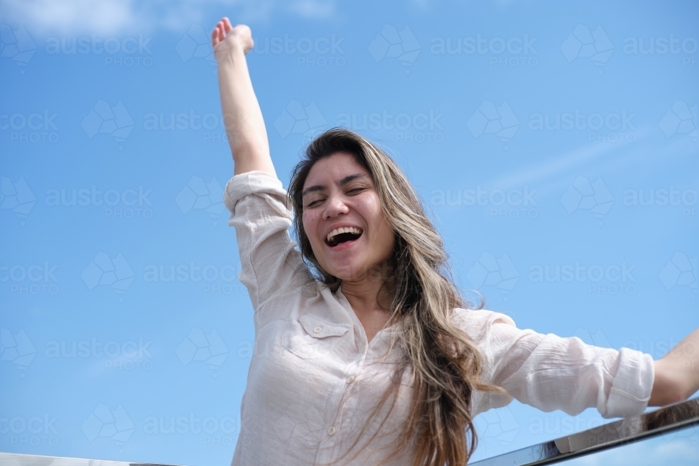 Image of Close-up photo of a woman happily leaning against the glass ...