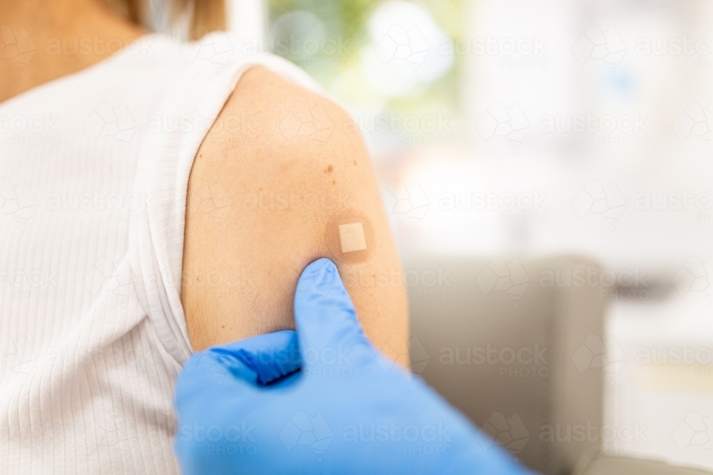 Image of close up shot of a hand putting a circular band aid on a ...