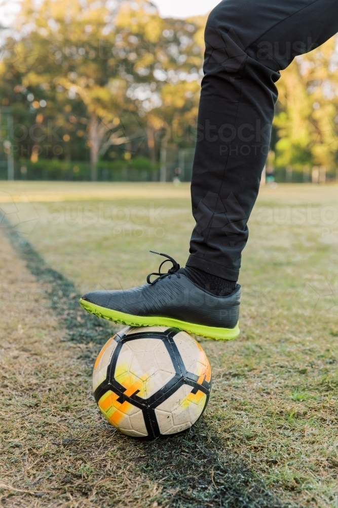 Image of Close up shot of a man stepping on a soccer ball with one foot ...