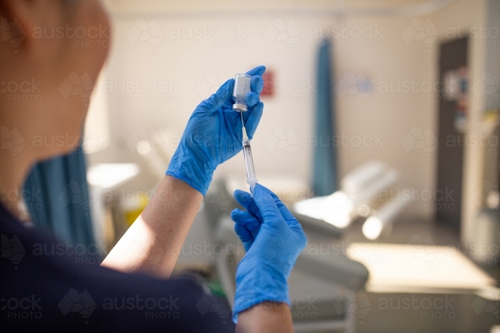 Image of Close up shot of a syringe being inserted to a medicine glass ...